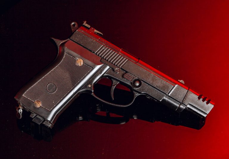 black hand gun on red background – Sandoval Sporting Range